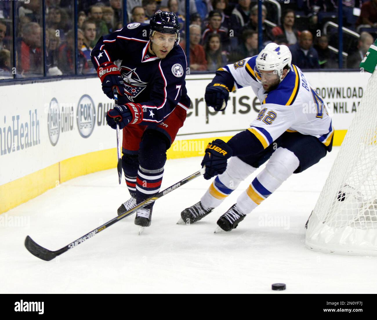 Columbus Blue Jackets' Jack Johnson, left, works for the puck against St. Louis BLues' David ...