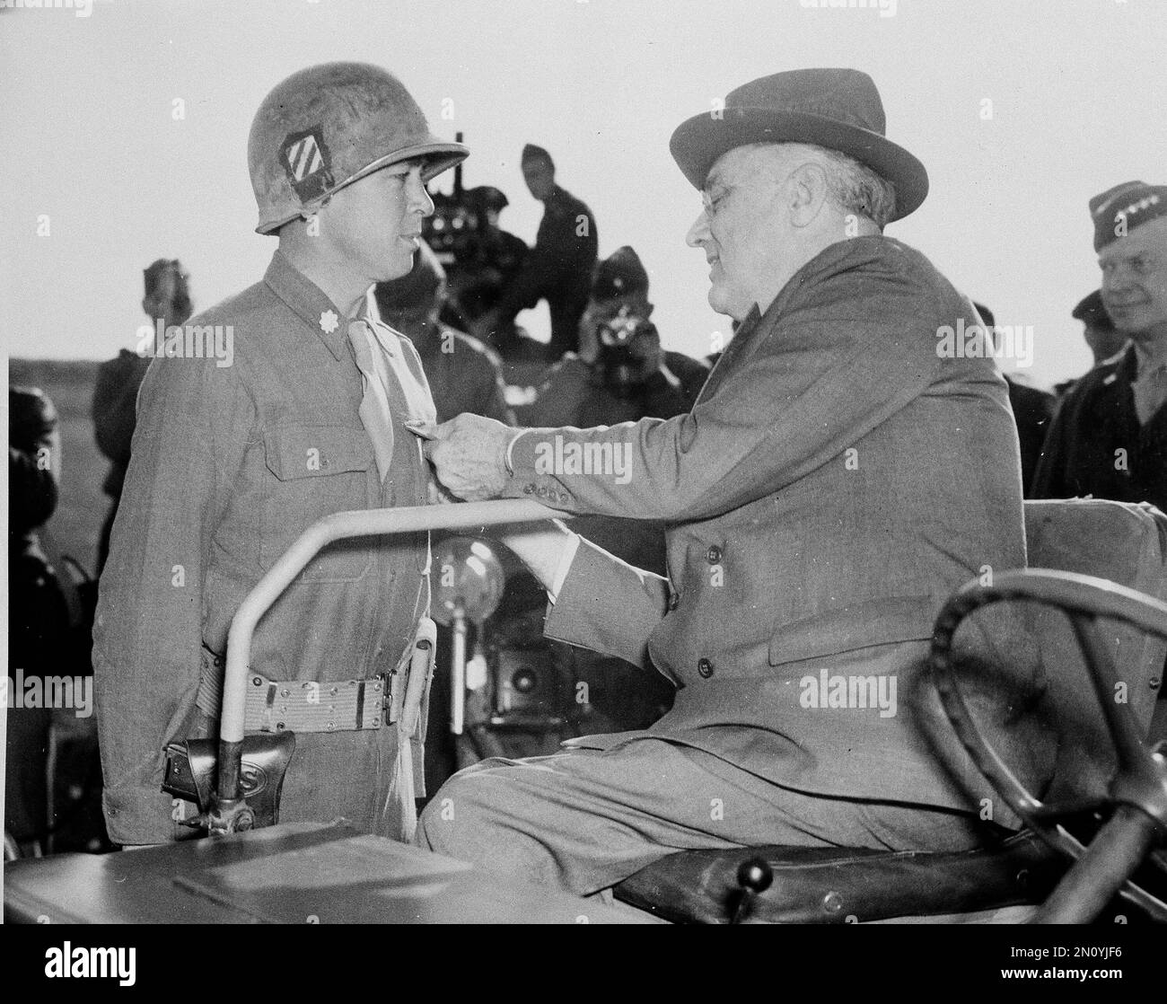 In this photo provided by the U.S. Air Force, leaning from his jeep ...