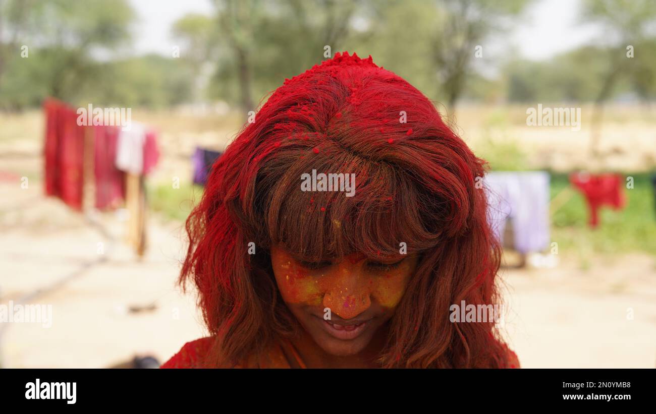 Beautiful young girl posing with exploding pink and yellow Holi powder ...