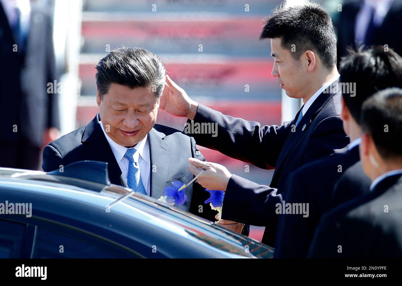 China's President Xi Jinping is helped into his car by his security ...