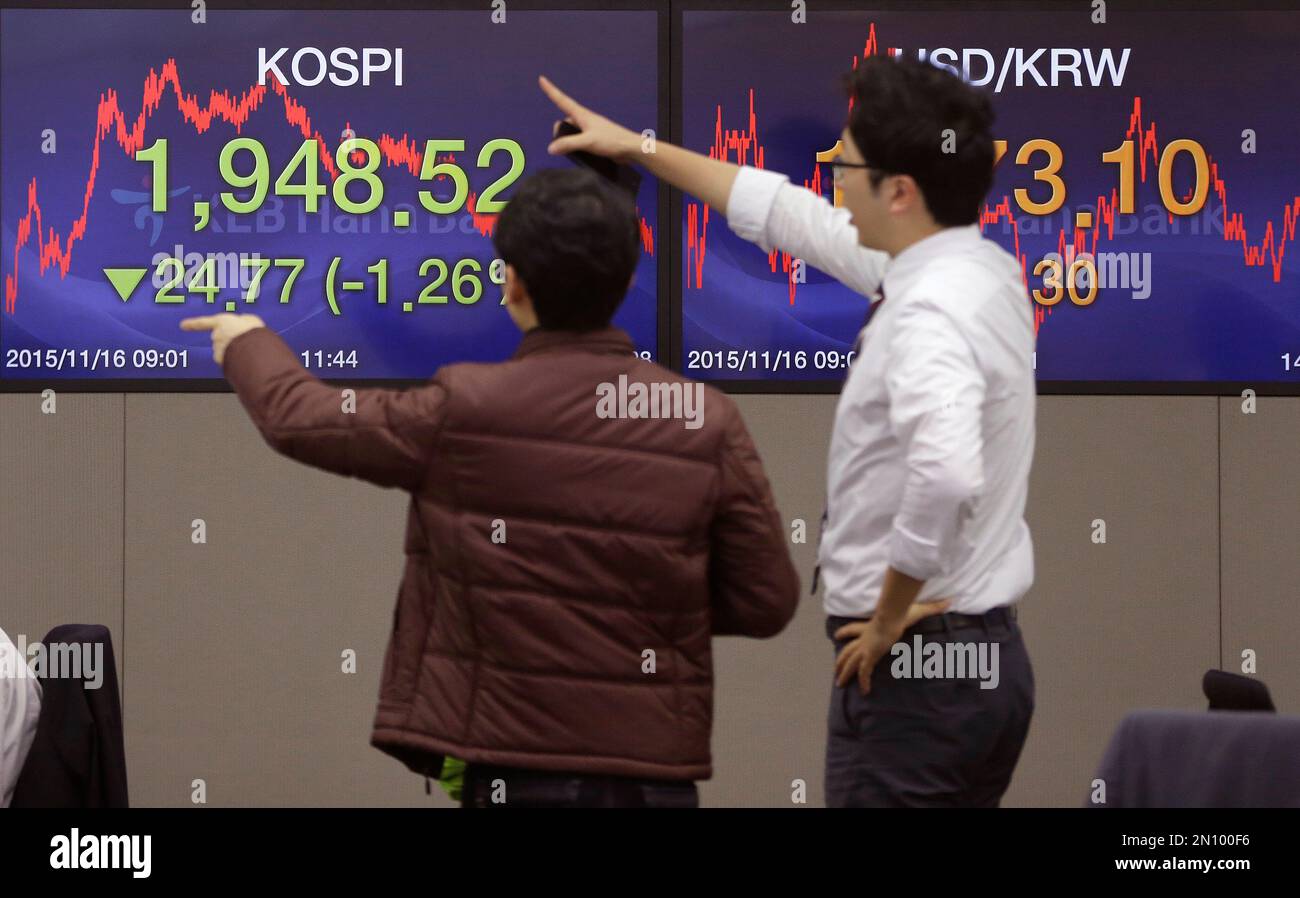 Currency traders watch screens showing the Korea Composite Stock Price ...