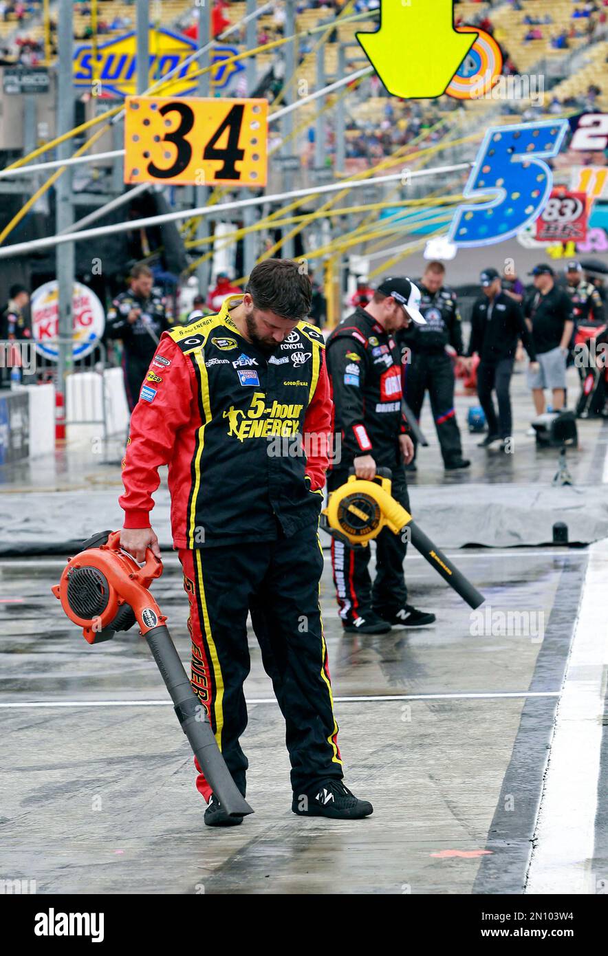 A pit crew member for Clint Bowyer uses a leaf blower to dry the team's ...
