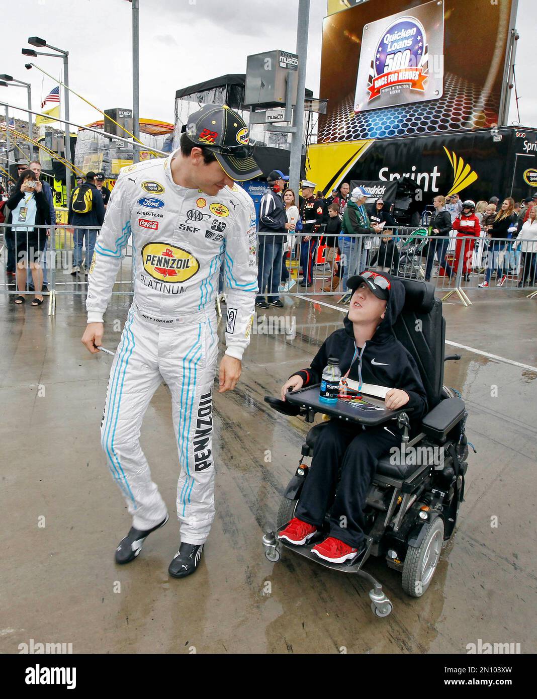 Joey Logano, left, walks with 14-year-old Gavin Grubbs before the ...