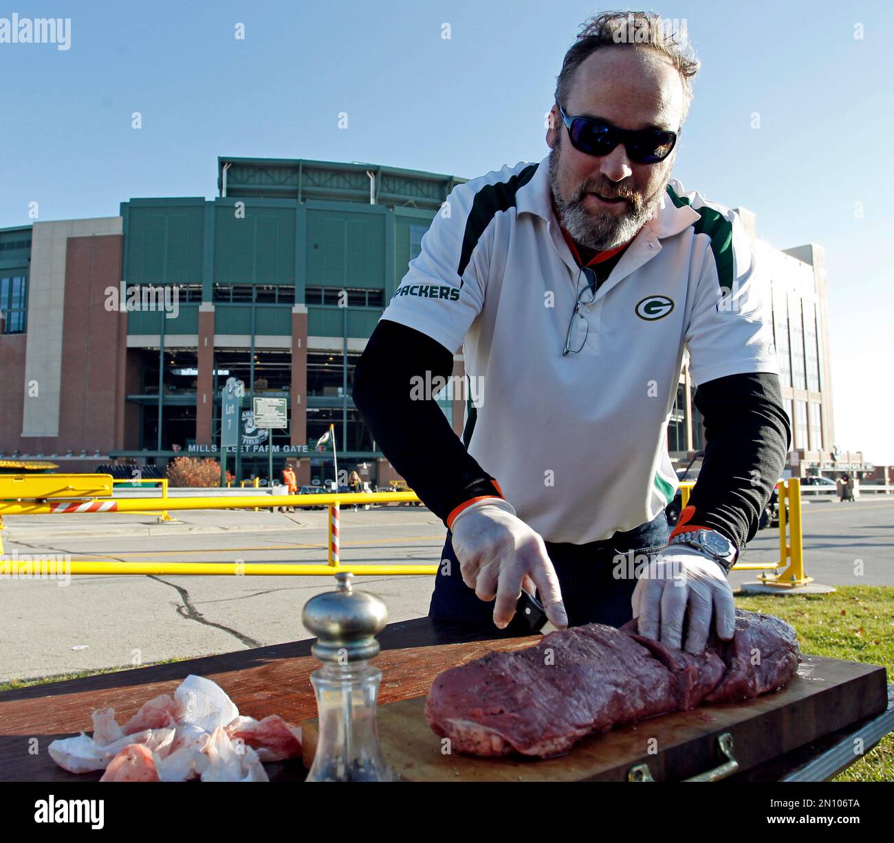 Joe Conway gets some meat ready to grill outside Lambeau Field before ...