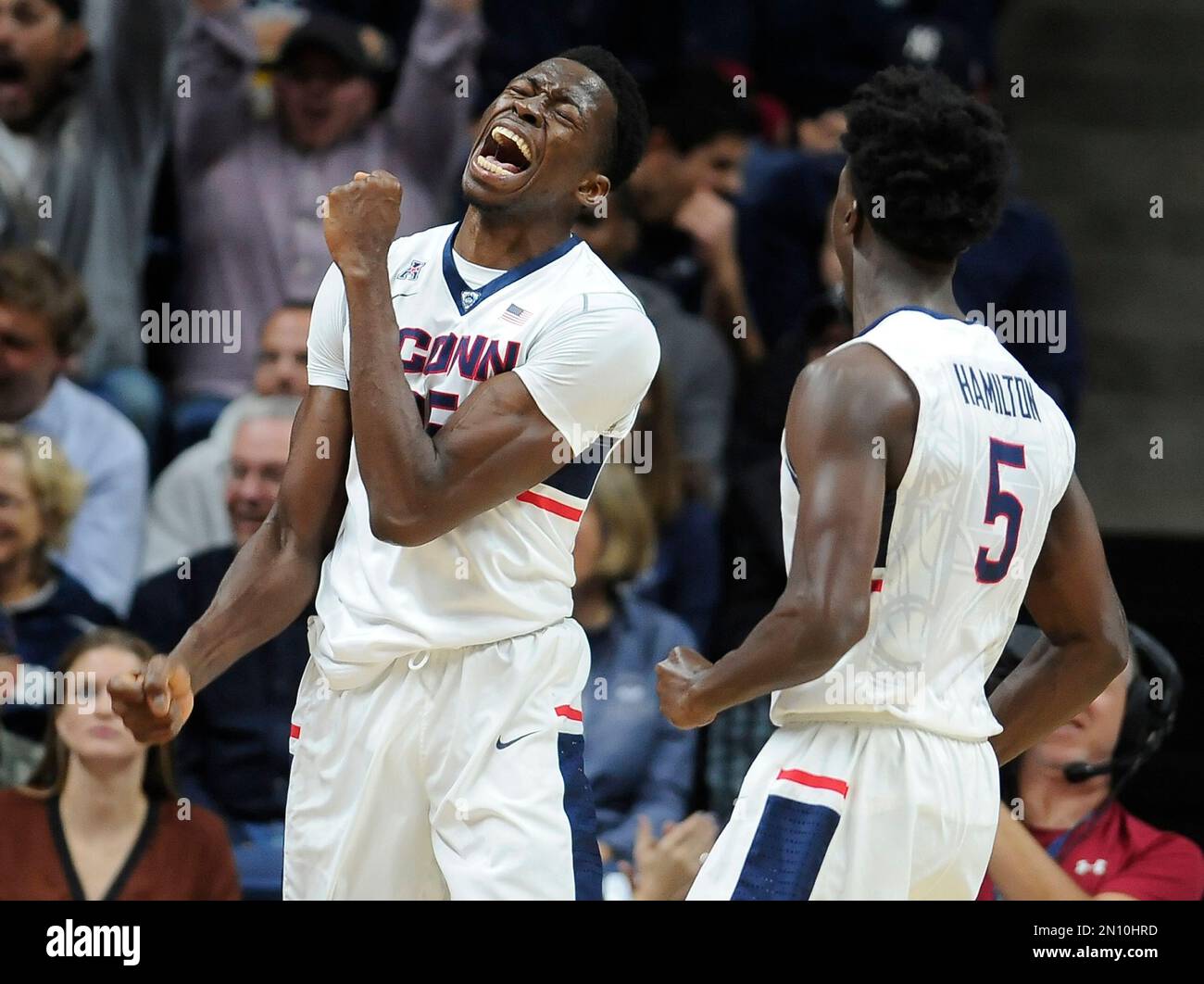 Connecticut's Amida Brimah, left, and Daniel Hamilton, right, react ...