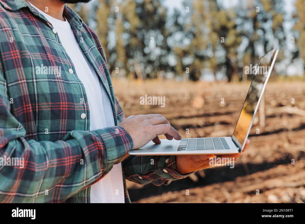 Close up unrecognizable farmer man teleworking on his computer in the ...