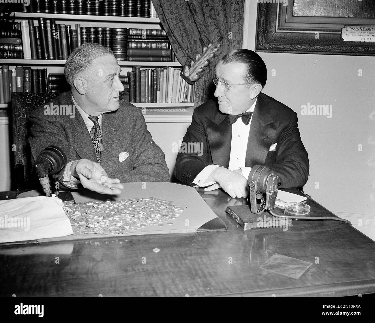 President Franklin D. Roosevelt looks over dimes donated in the ...