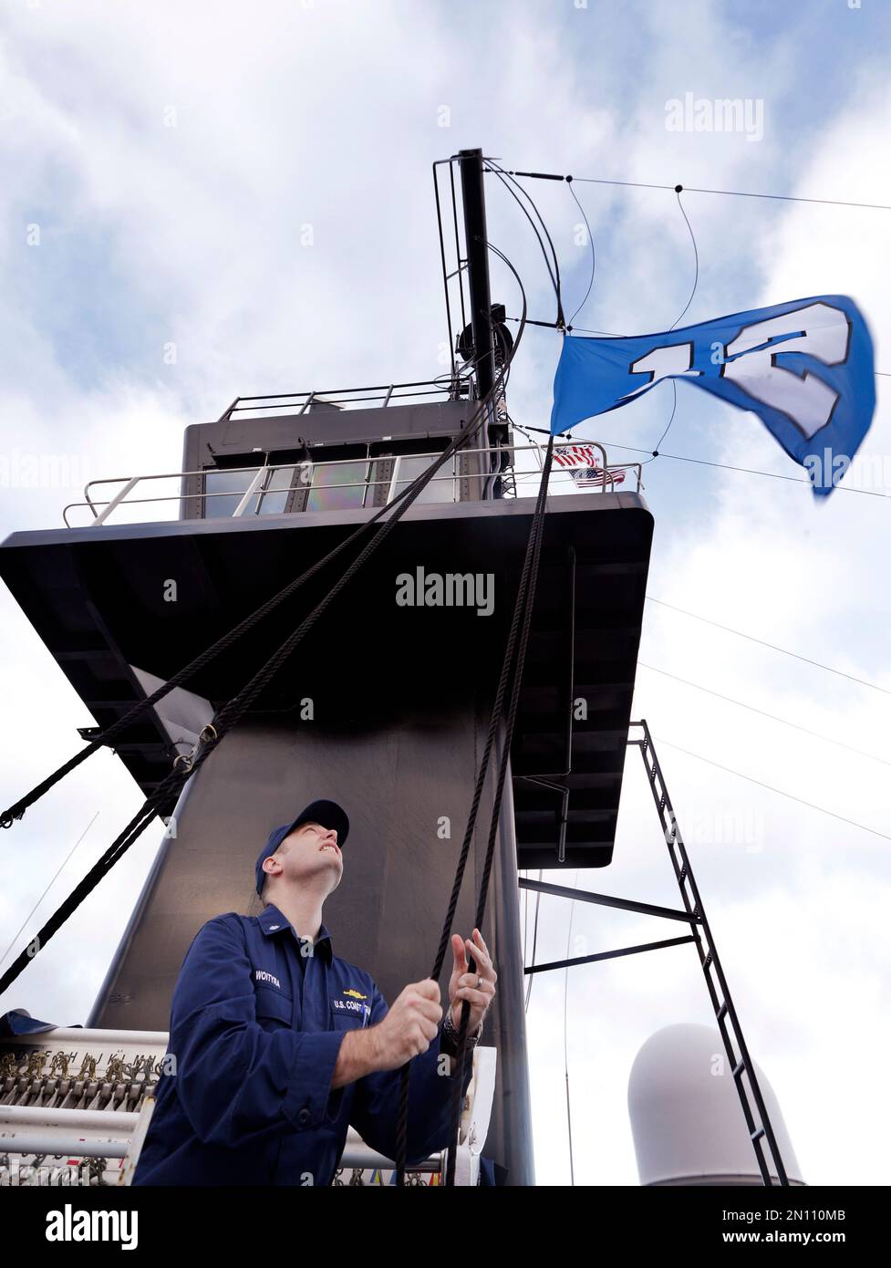 A crew member raises a "12th Man" flag, symbolic of support of the ...