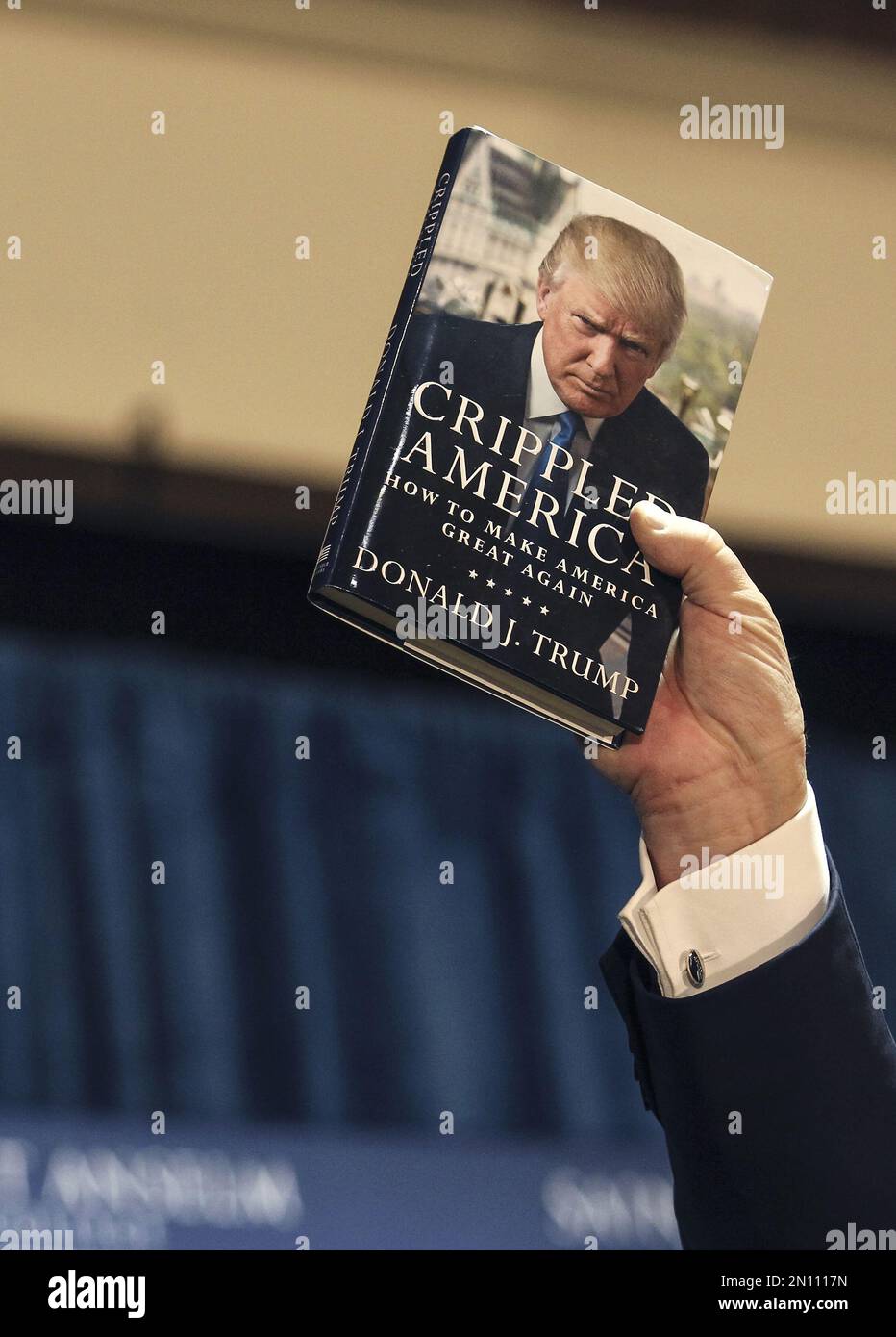 Republican presidential candidate Donald Trump holds up a copy of his ...