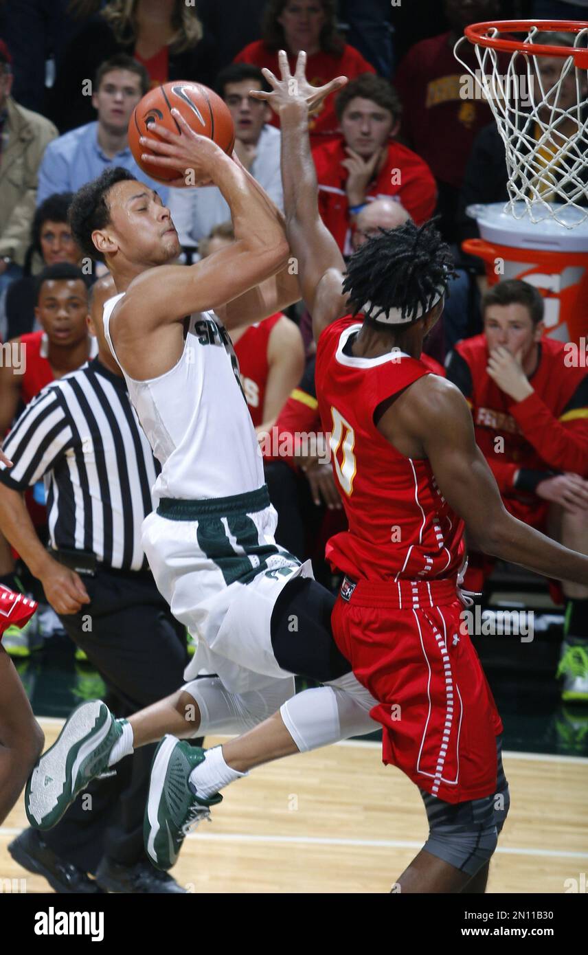 Michigan State's Bryn Forbes, center, shoots in front of Ferris State's ...