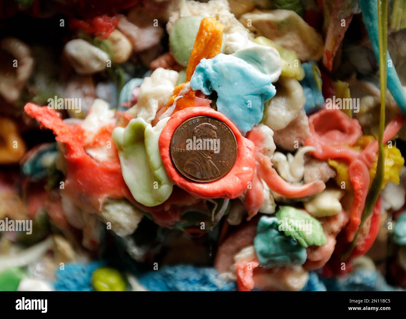 A penny is stuck to layers of gum on a wall at Seattle's "gum wall" at ...