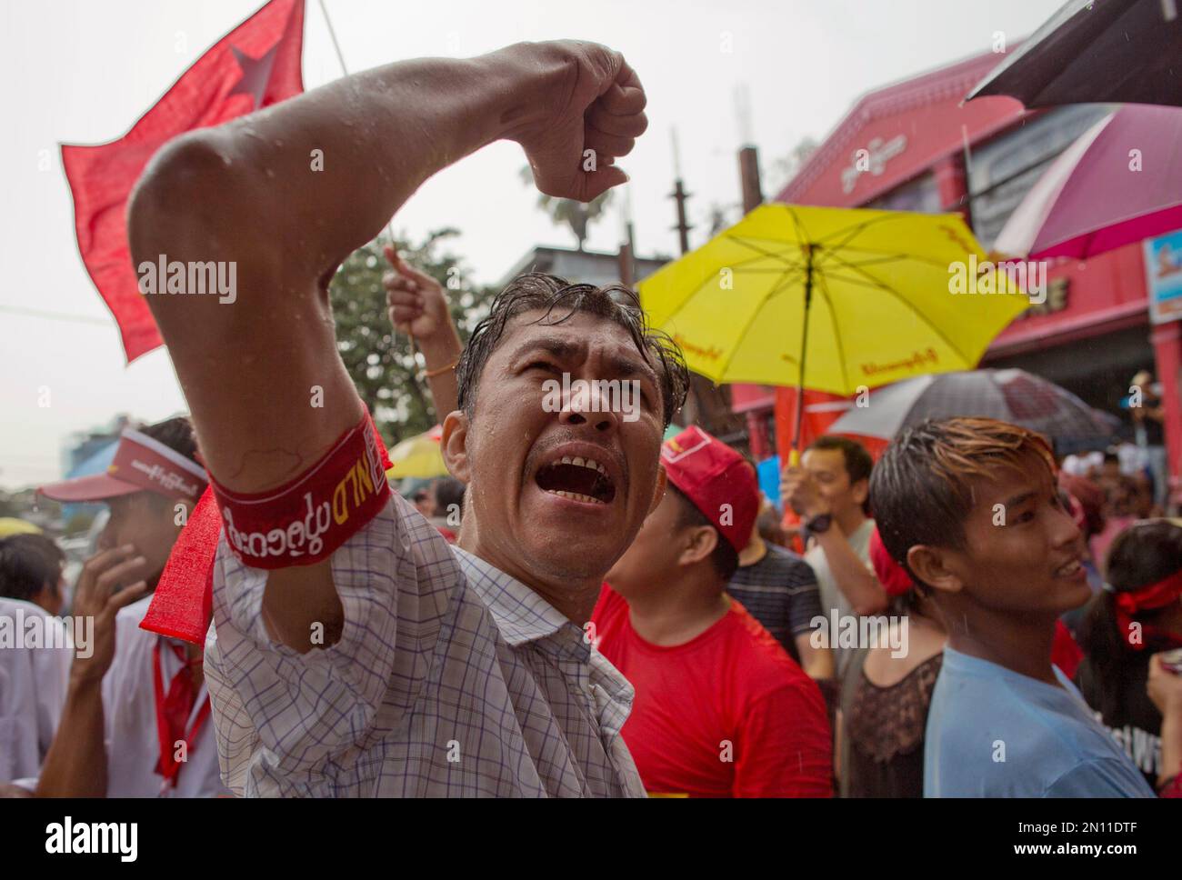 Braving rain, a supporter of Myanmar's National League for Democracy ...