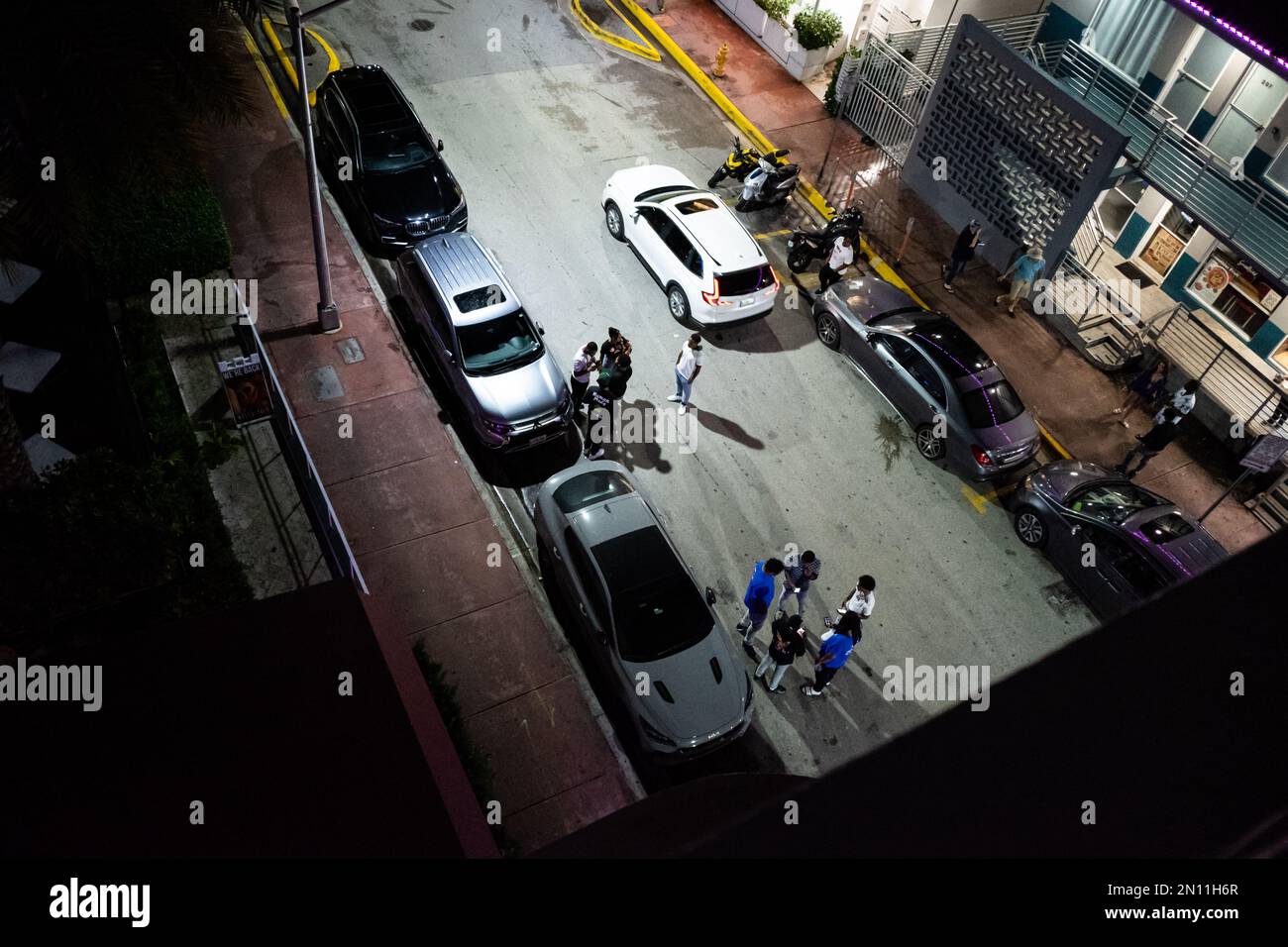 Street night photo from a rooftop looking down at two groups of young ...