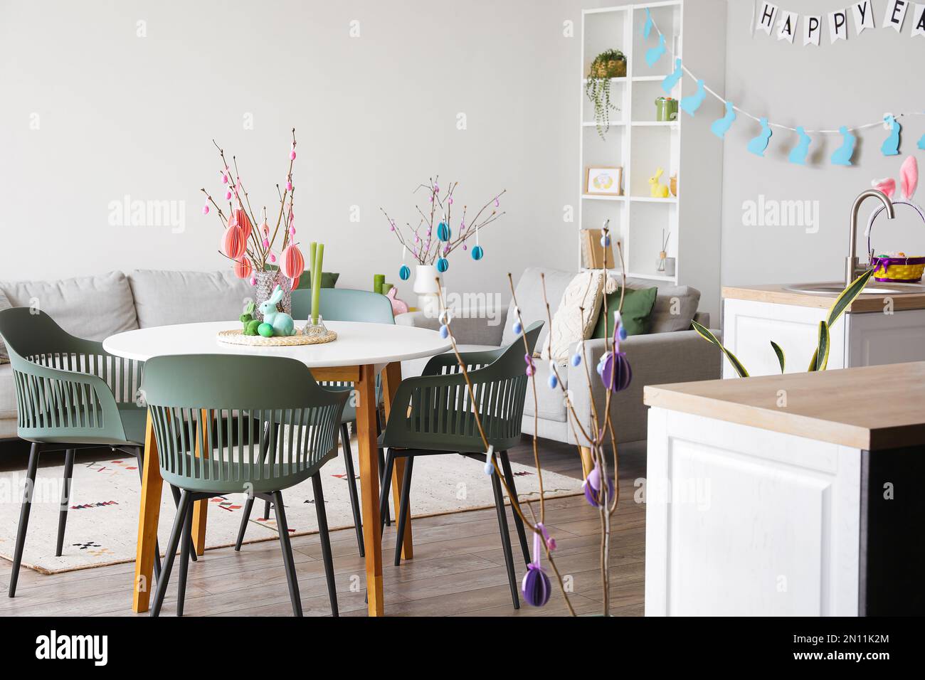 Interior of kitchen with tree branches, Easter eggs and dining table ...