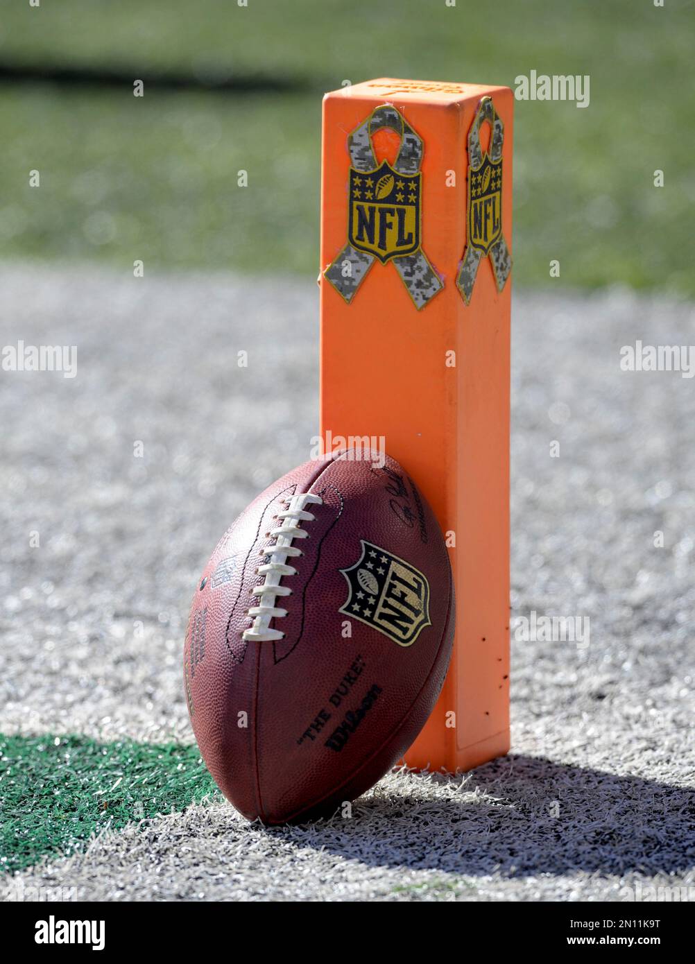 A game ball rests on a goal marker decorated with a Salute to Service ...