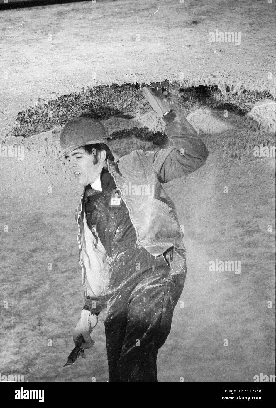 An unidentified FBI agent knocks plaster down from the second floor ...