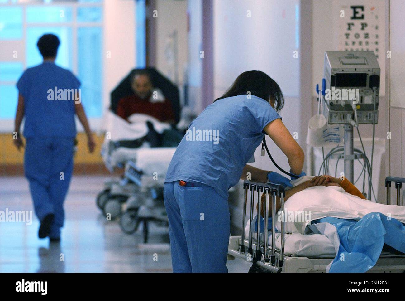 A medical student checks on a patient in the hallway of the emergency ...
