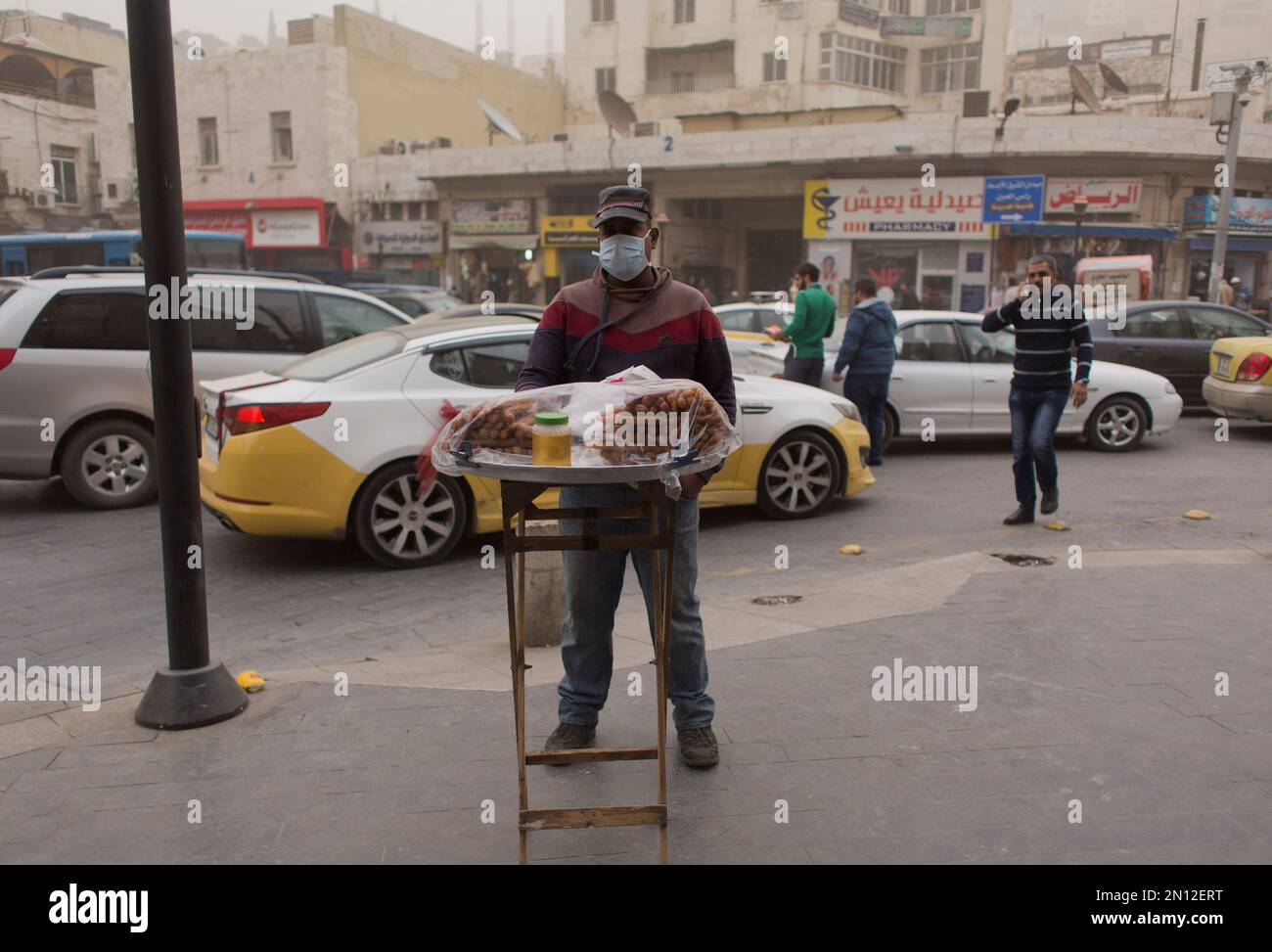 A Jordanian street vendor wears a mask during a sandstorm that engulfed ...