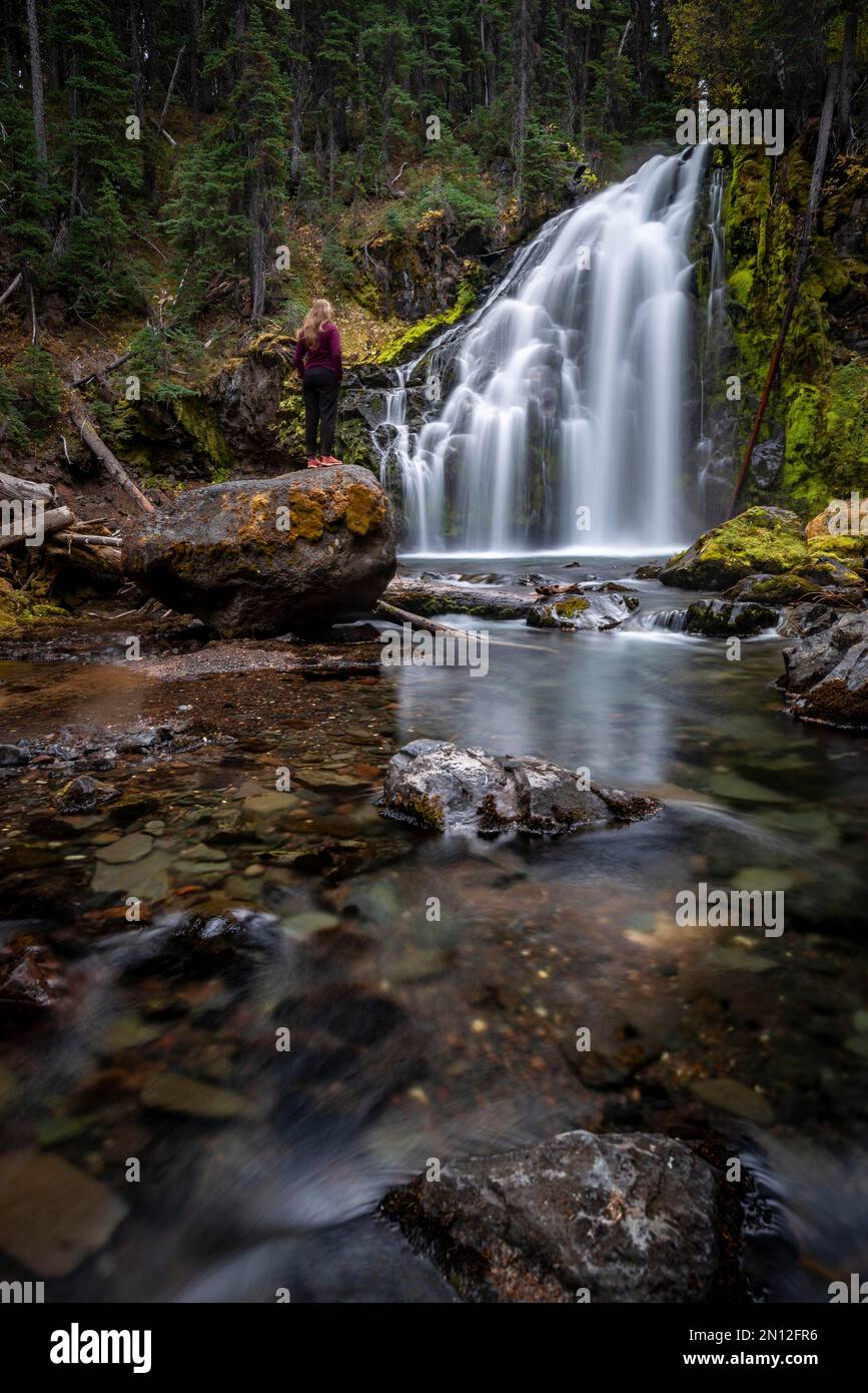 Young woman standing on stone, waterfall, Middle Tumalo Falls, long ...