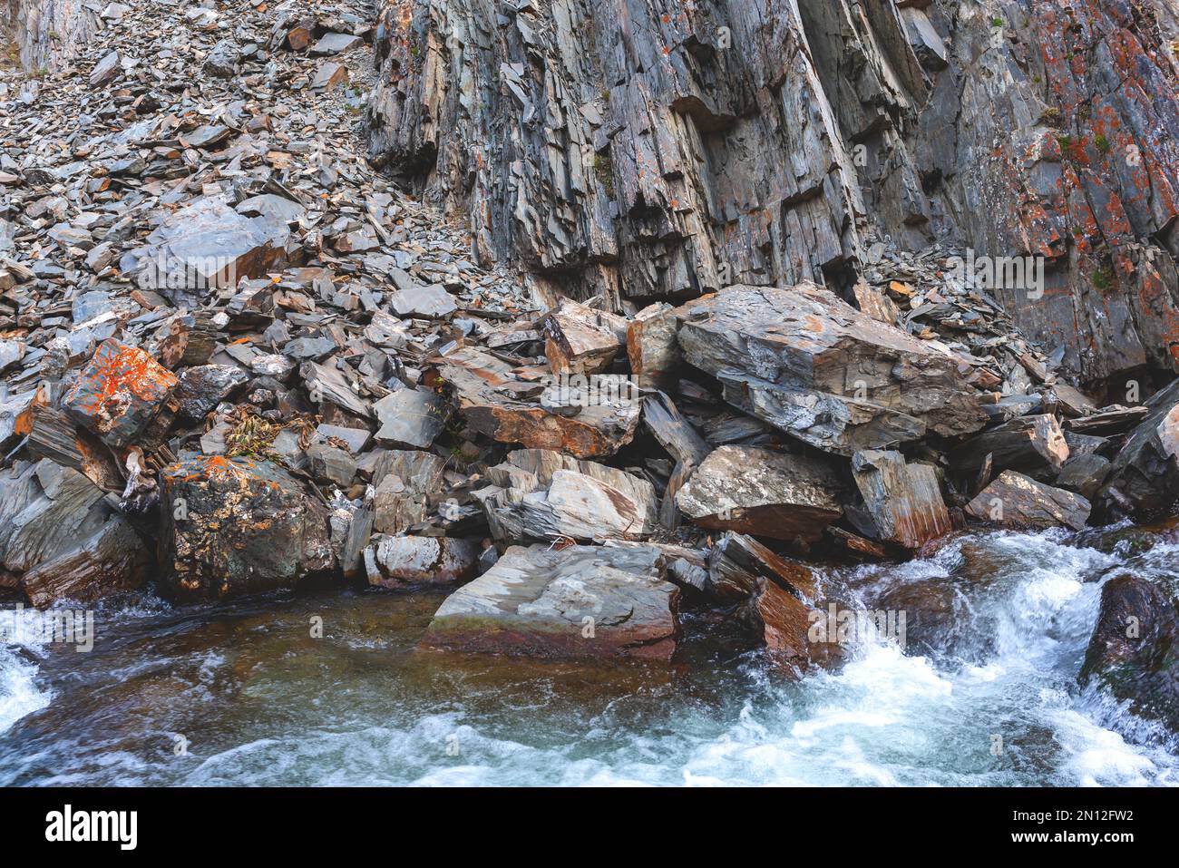 The fast flow of a clear mountain stream among the stones of the rocks ...