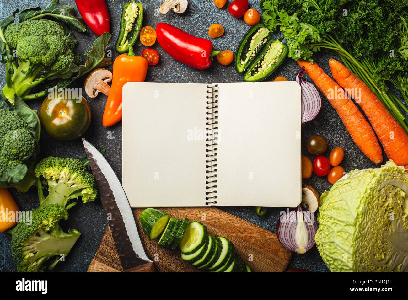 Empty paper notepad and assorted fresh vegetables on rustic concrete ...
