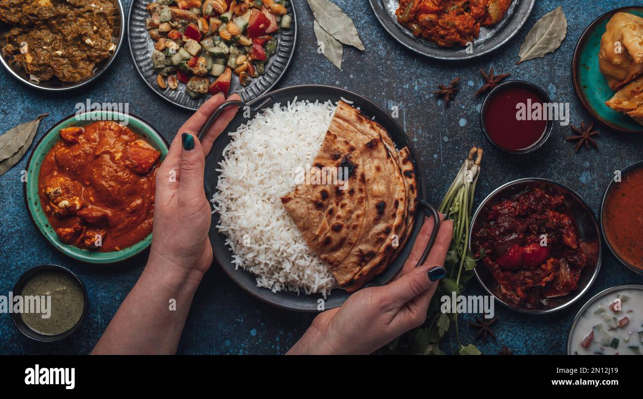 Assorted Indian ethnic food buffet on rustic concrete table from above ...