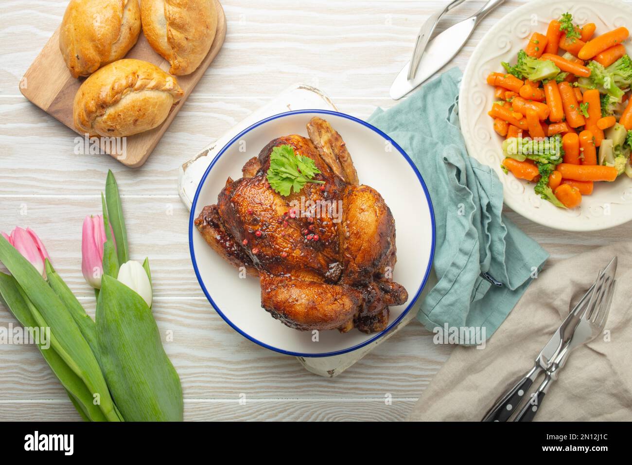Easter food on white rustic table: roasted chicken and vegetables, buns ...