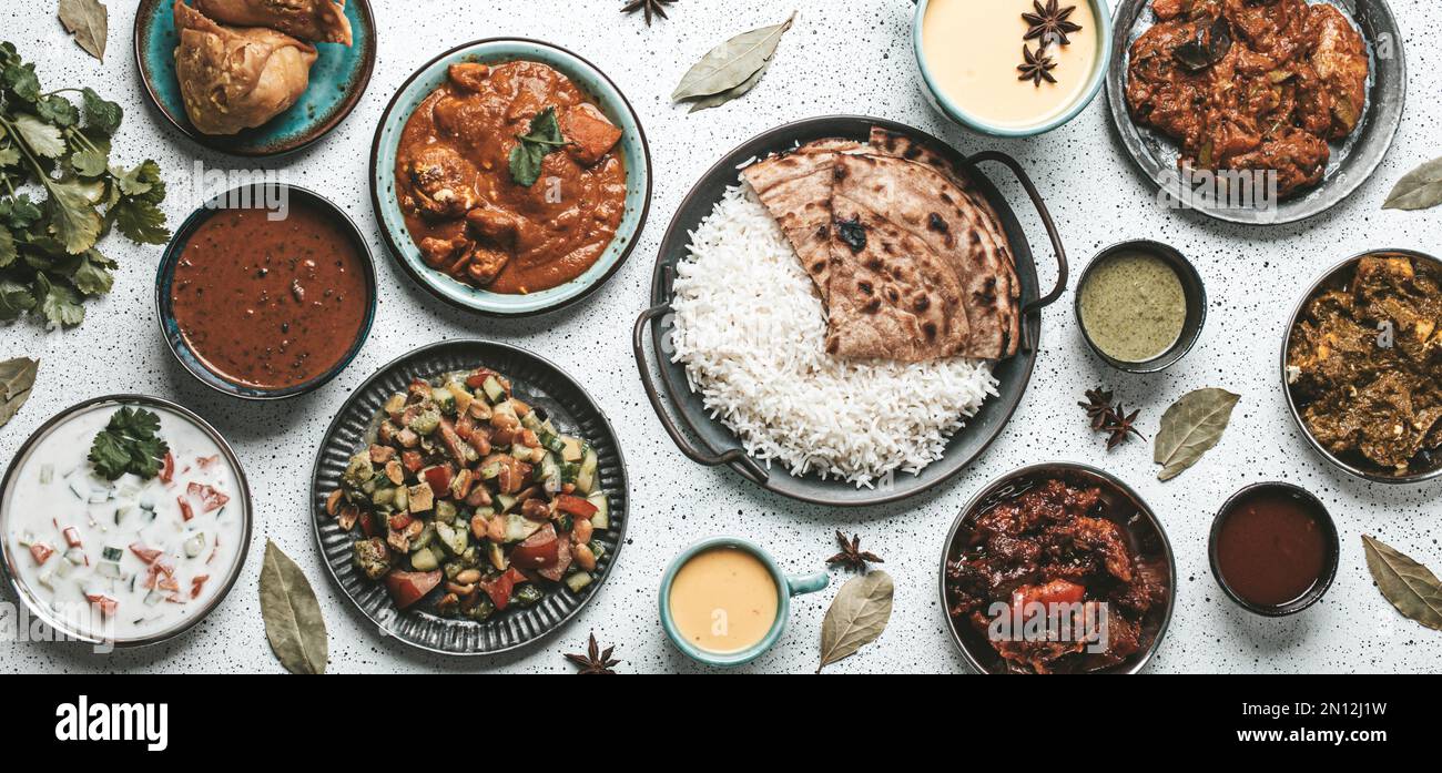 Indian ethnic food buffet on white concrete table from above: curry ...