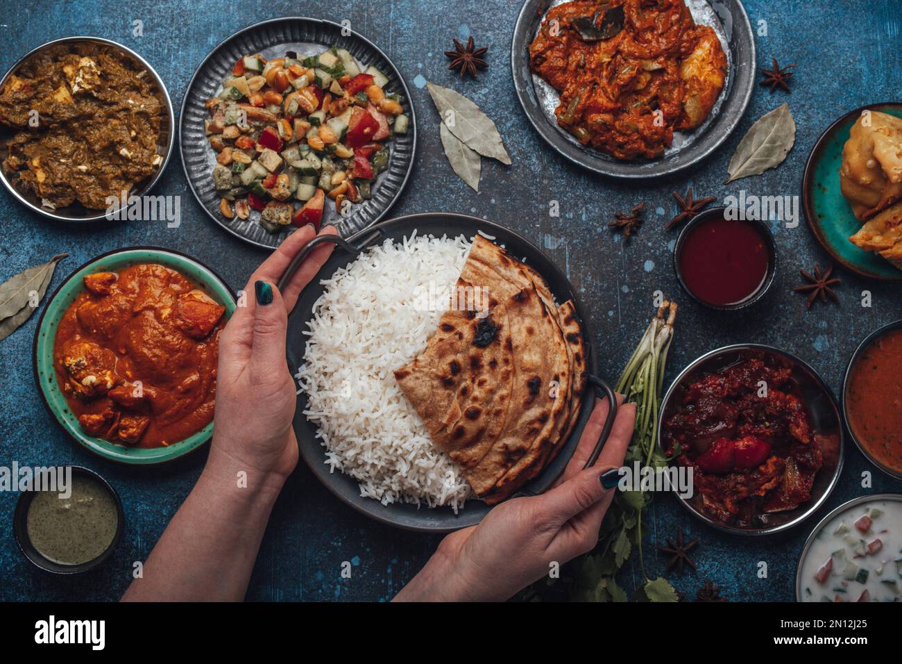 Assorted Indian ethnic food buffet on rustic concrete table from above ...