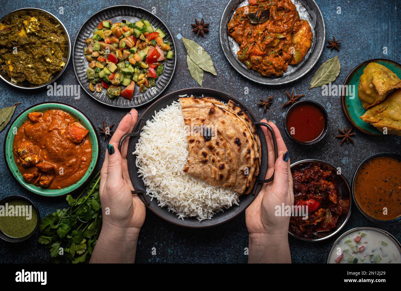 Assorted Indian ethnic food buffet on rustic concrete table from above ...