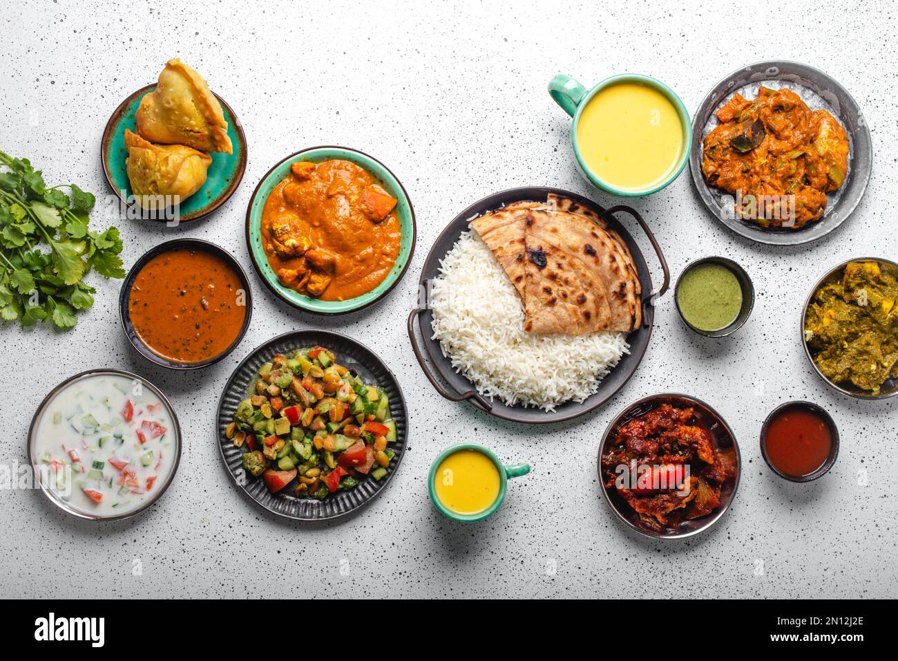 Indian ethnic food buffet on white concrete table from above: curry ...