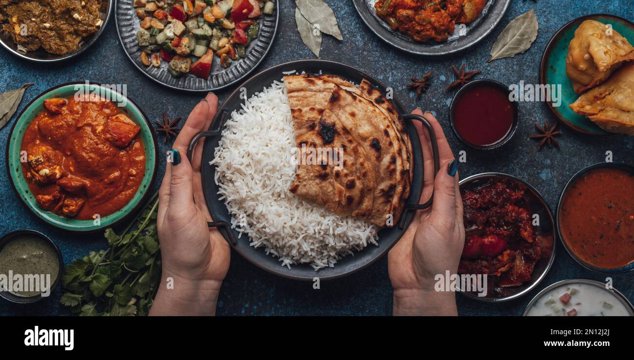 Assorted Indian ethnic food buffet on rustic concrete table from above ...