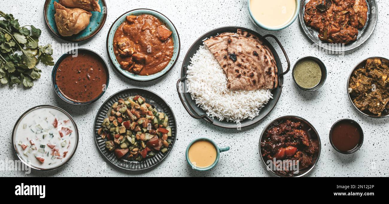 Indian ethnic food buffet on white concrete table from above: curry ...