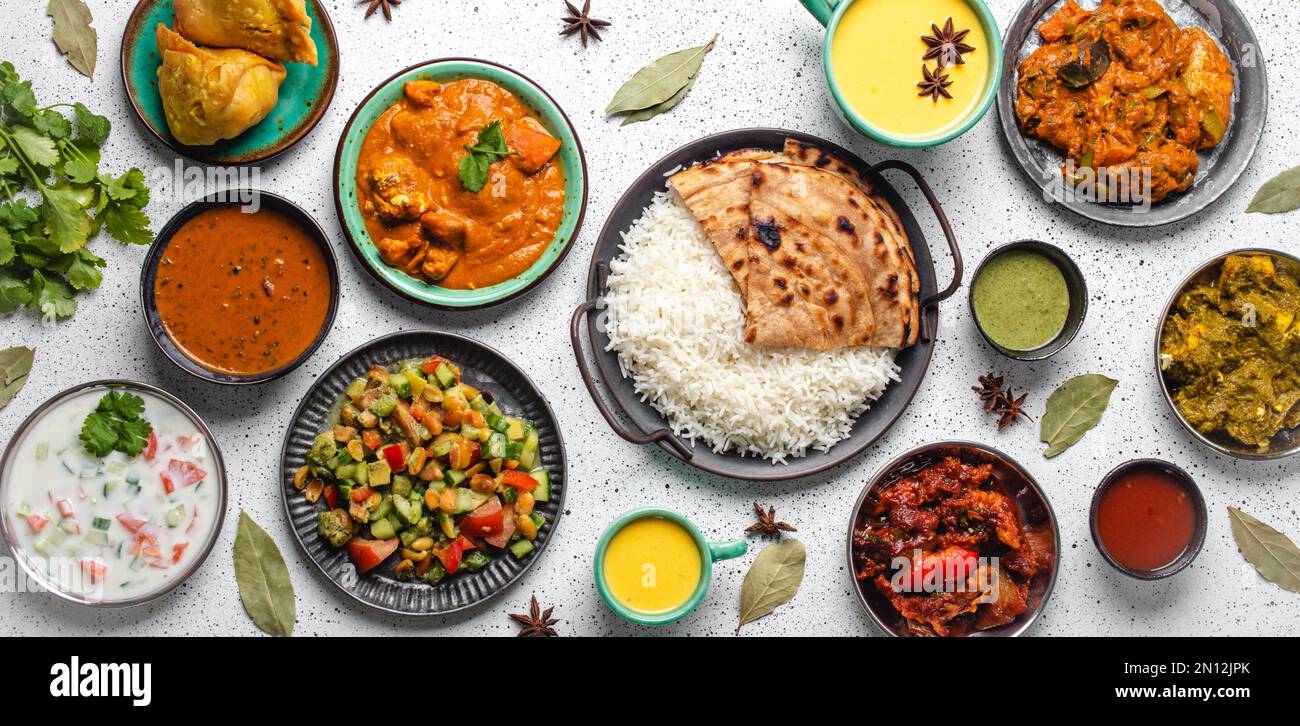 Indian ethnic food buffet on white concrete table from above: curry ...