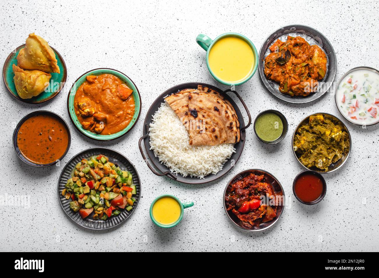 Indian ethnic food buffet on white concrete table from above: curry ...
