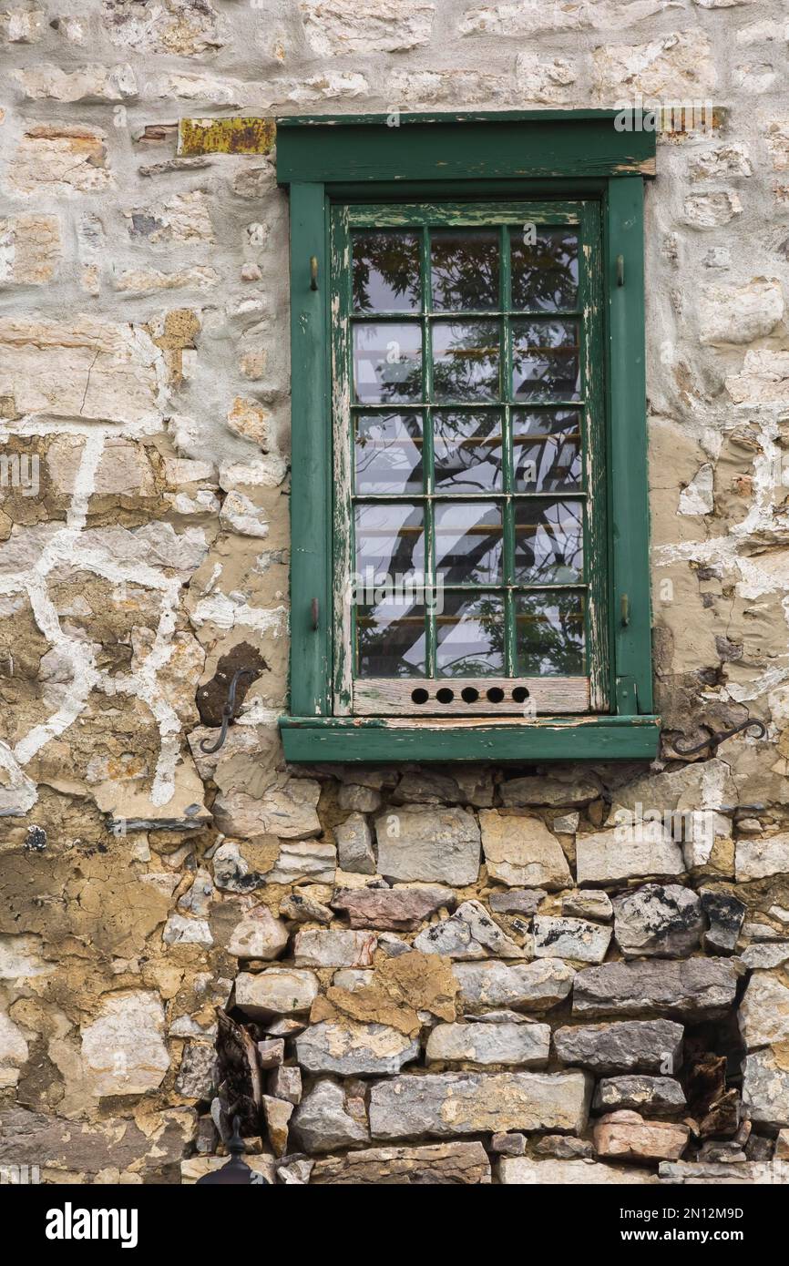 Green wooden window on the side wall of an old house ca. 1750, known as ...