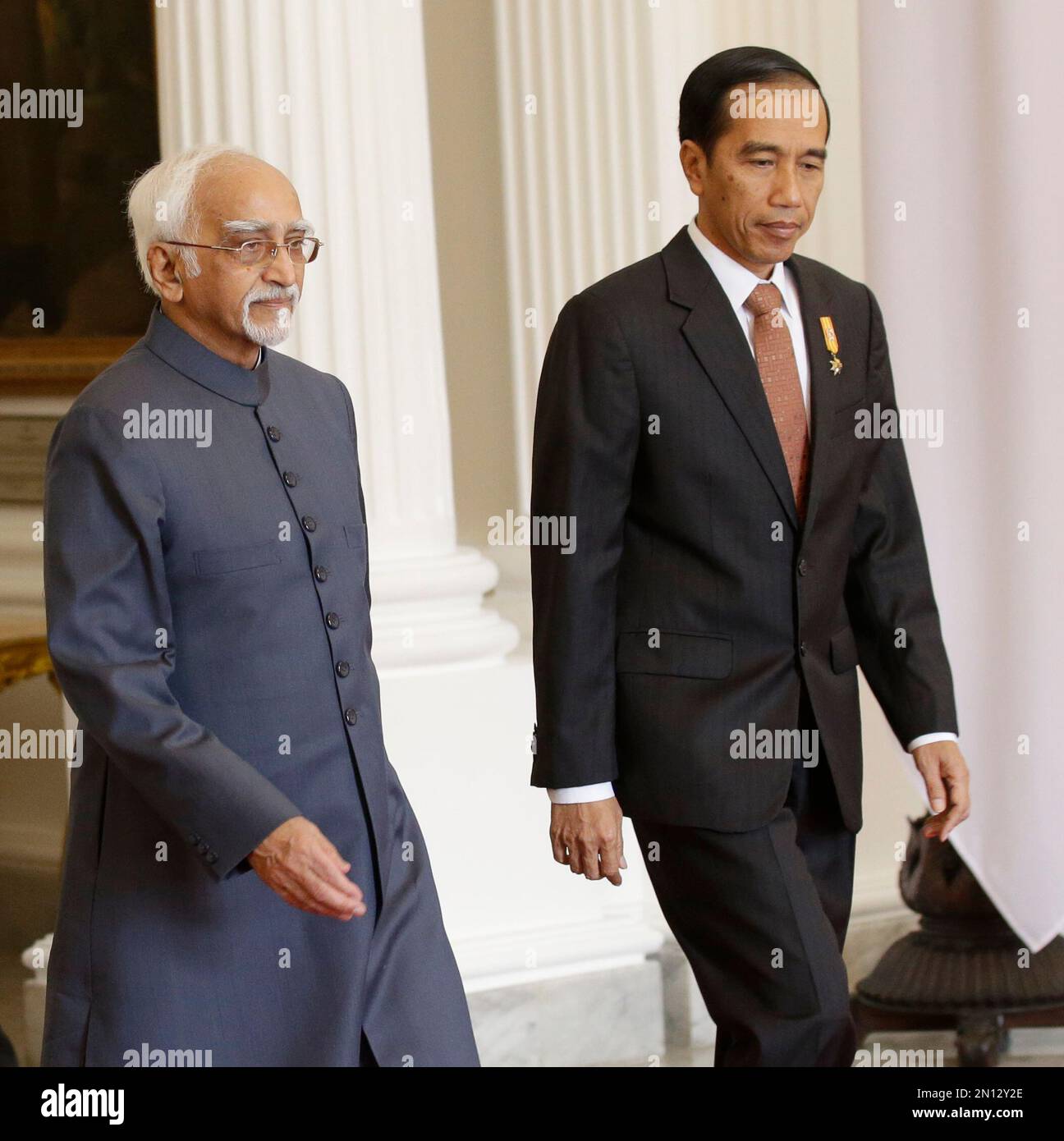 Indian Vice President Mohammad Hamid Ansari, left, walks with Indonesian President Joko Widodo ...