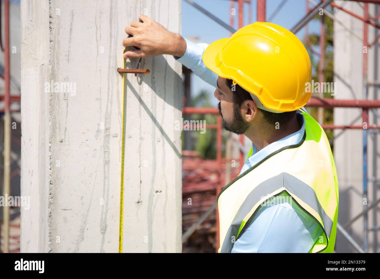 Engineer young man using tape measure for check and examining length of ...