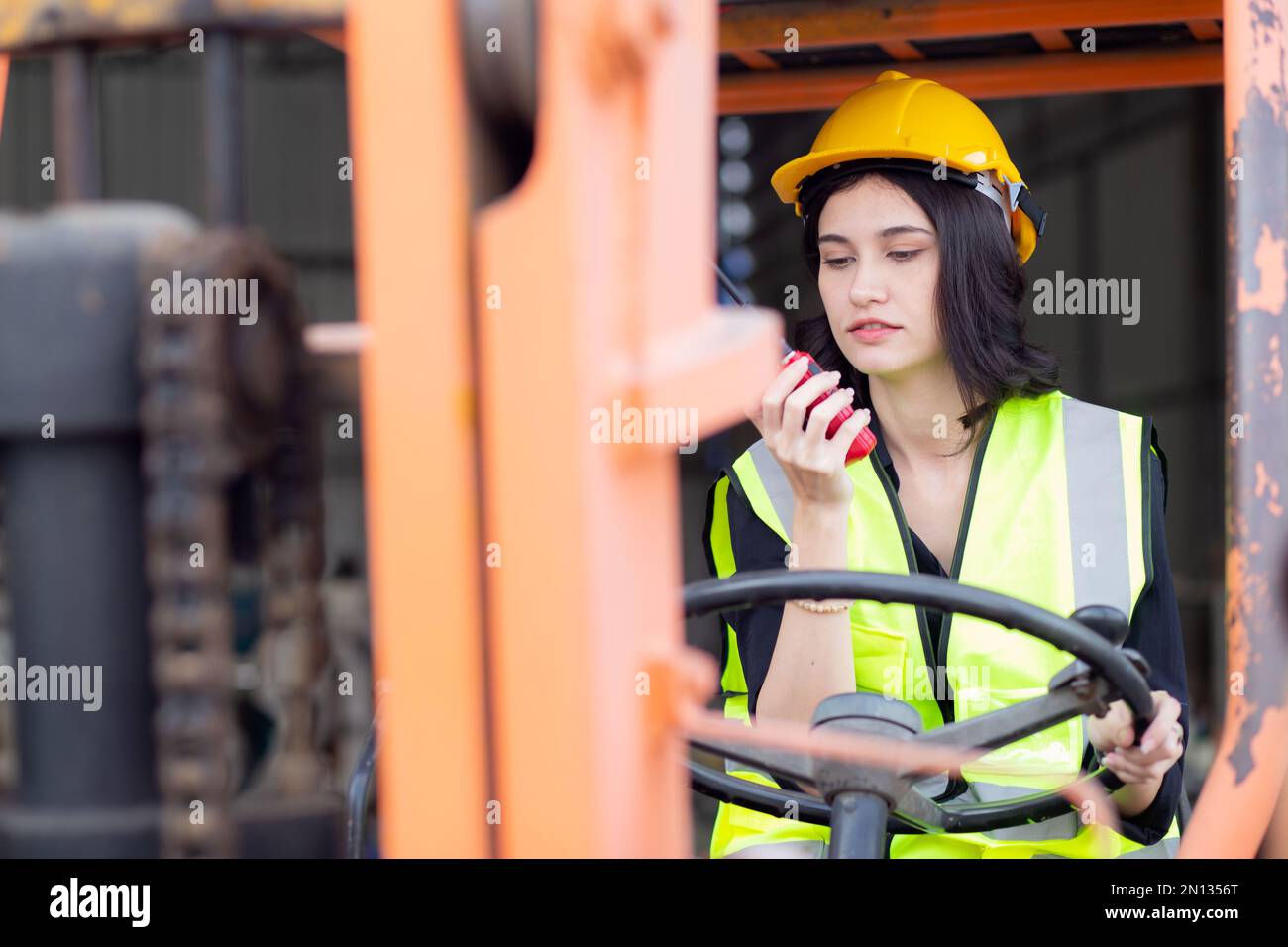 Young asian woman is foreman using radio for communication while ...