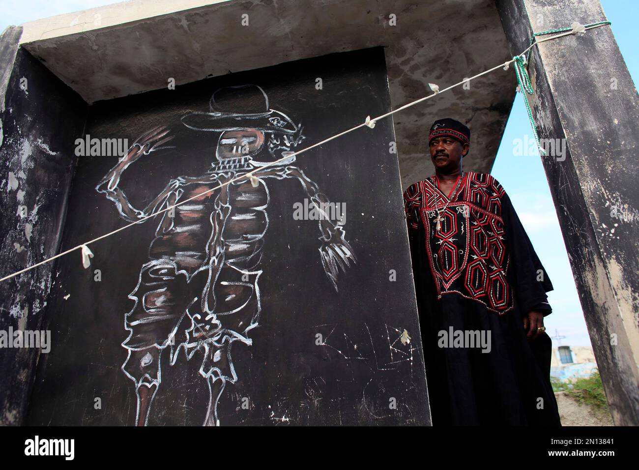 A Voodoo believer looks on from top of a grave during a Voodoo ritual ...