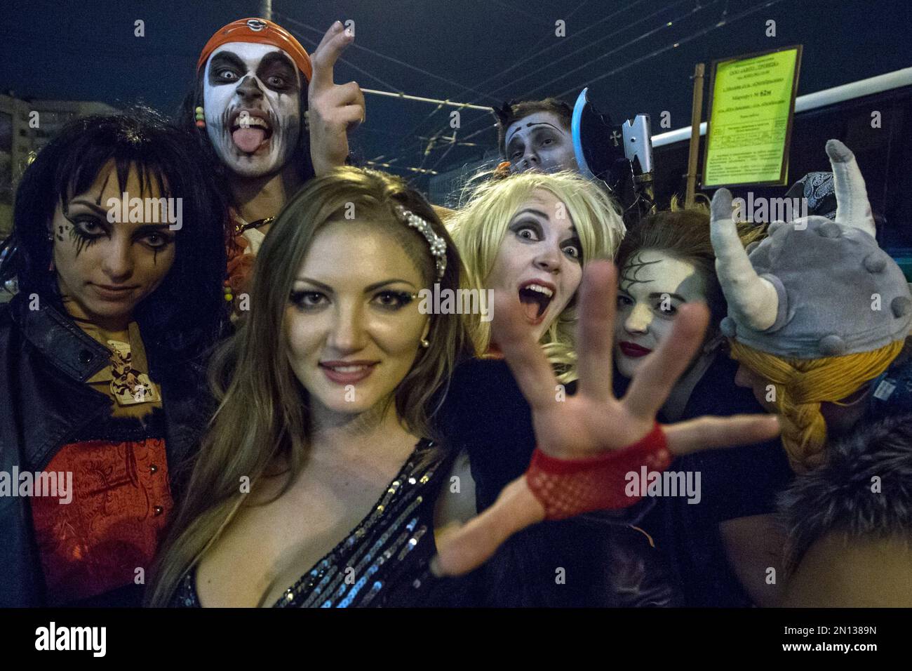 People dressed in Halloween costumes pose for a photo as they attend ...