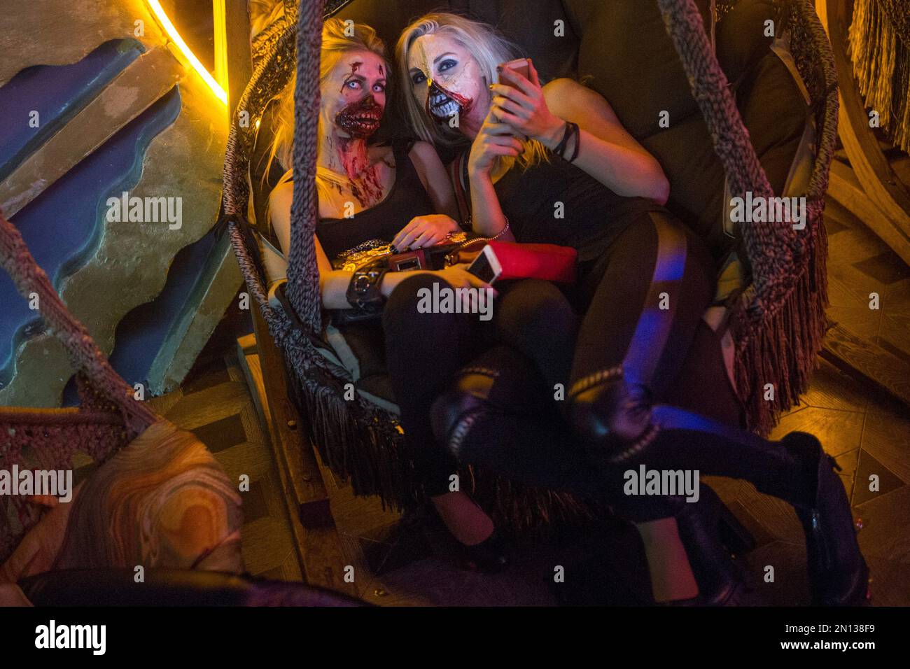 Women dressed in Halloween costumes attend the Halloween celebration in ...