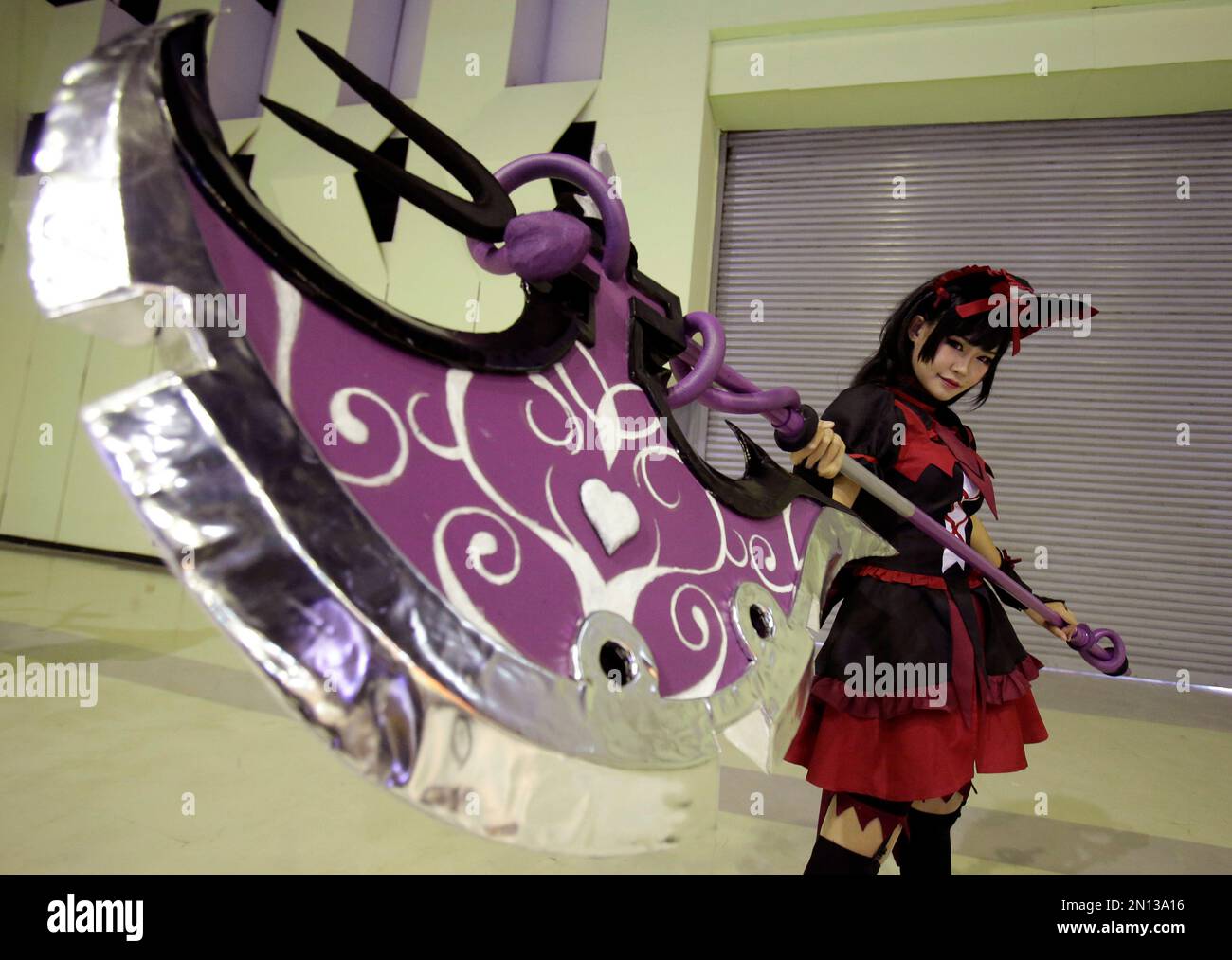 A person wearing a costume poses for anime fans at a shopping mall ...