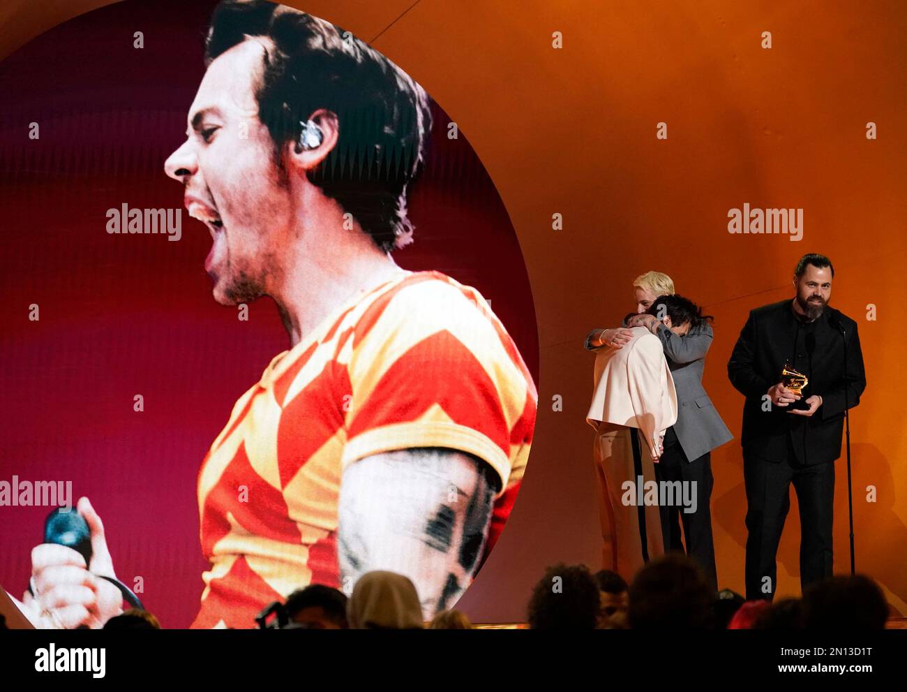 Harry Styles, left, embraces Kid Harpoon, center, while Tyler Johnson ...