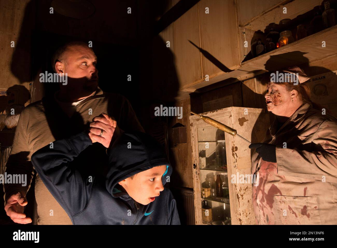 Actor Michelle Messer, right, scares guests at the entrance of the The ...