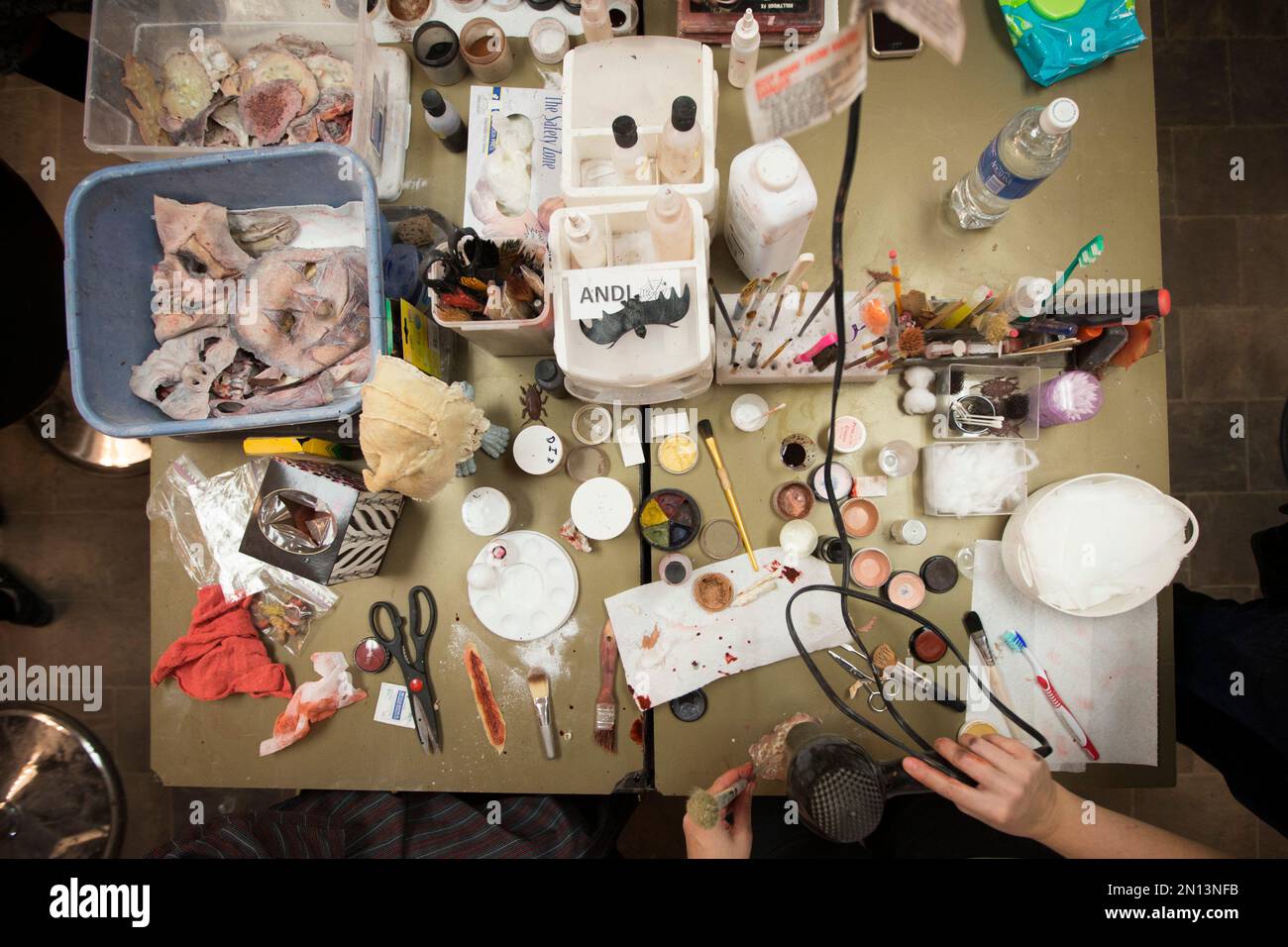 Makeup, prosthetics, and tools rest on a table during actor preparation ...