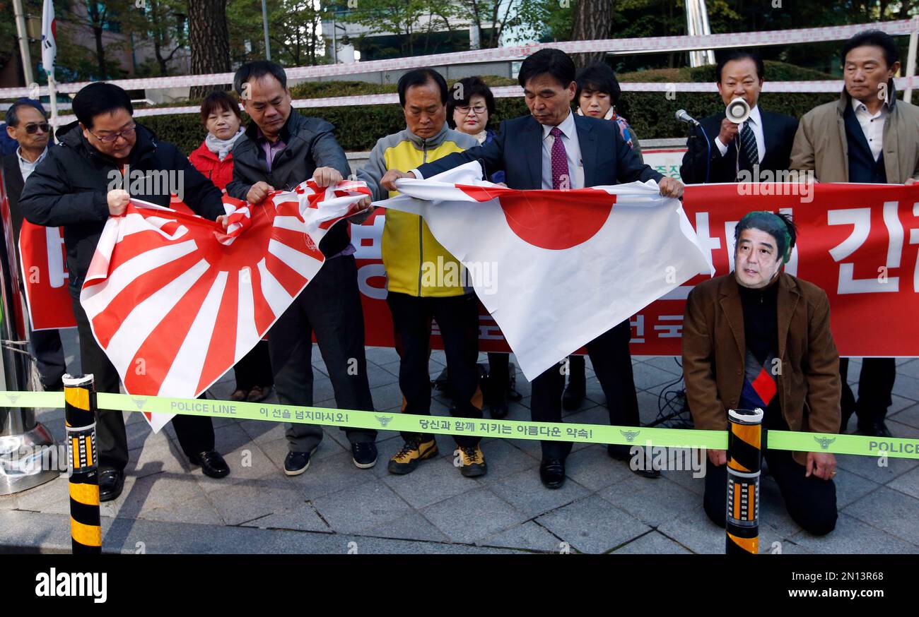 South Korean protesters tear a Japanese rising sun flag and a flag as ...