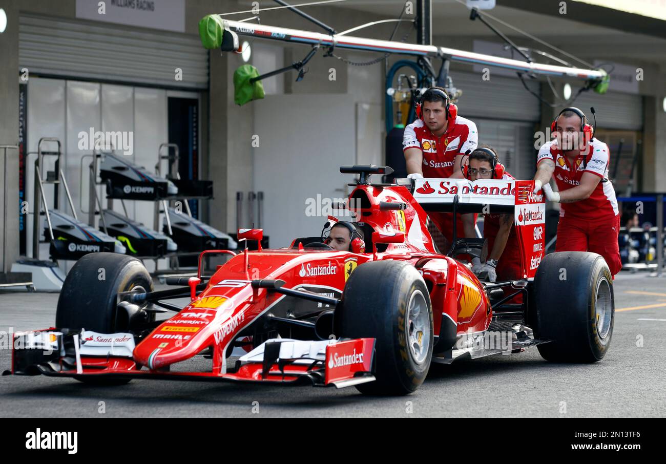 Ferrari mechanics push one of their vehicles in order to do a tire ...