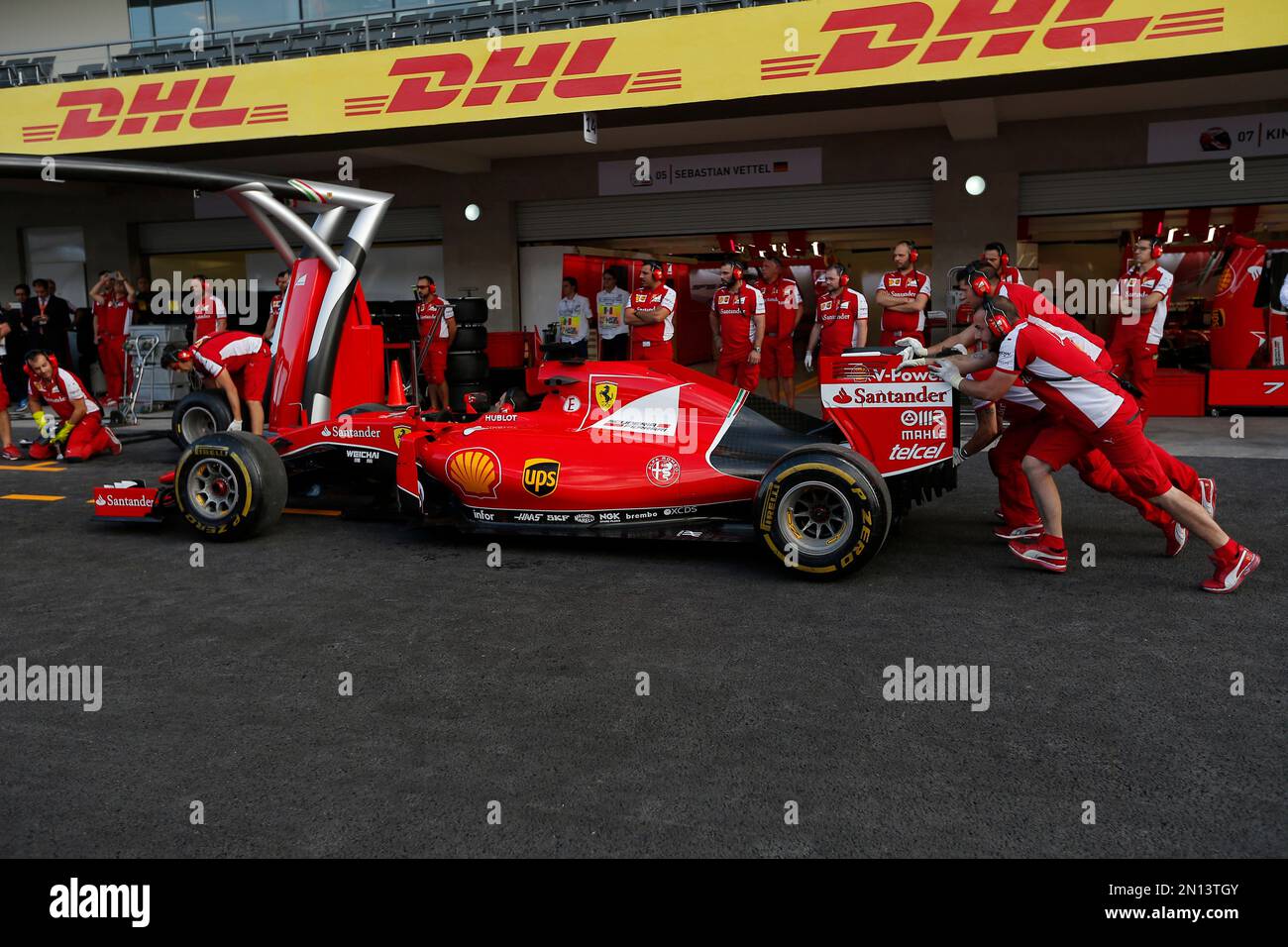 Ferrari mechanics push one of their vehicles in order to do a tire ...