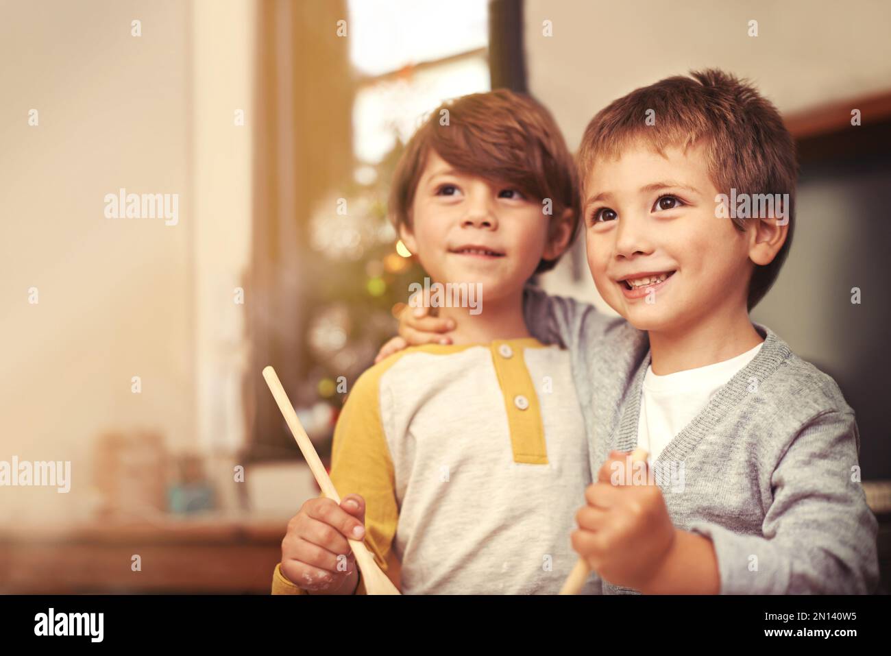 Well bake over the world. two young brothers baking in the kitchen ...